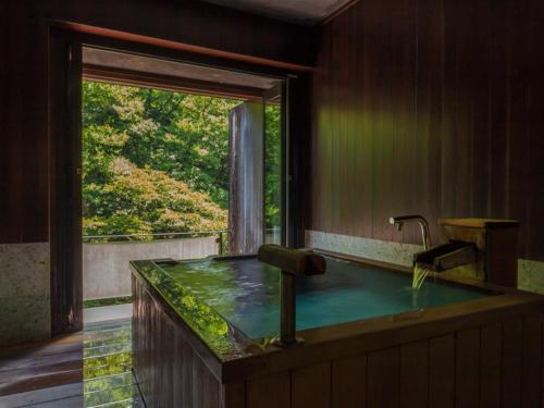 Watch the clear stream of Shima River from the giant open-air bath at ...